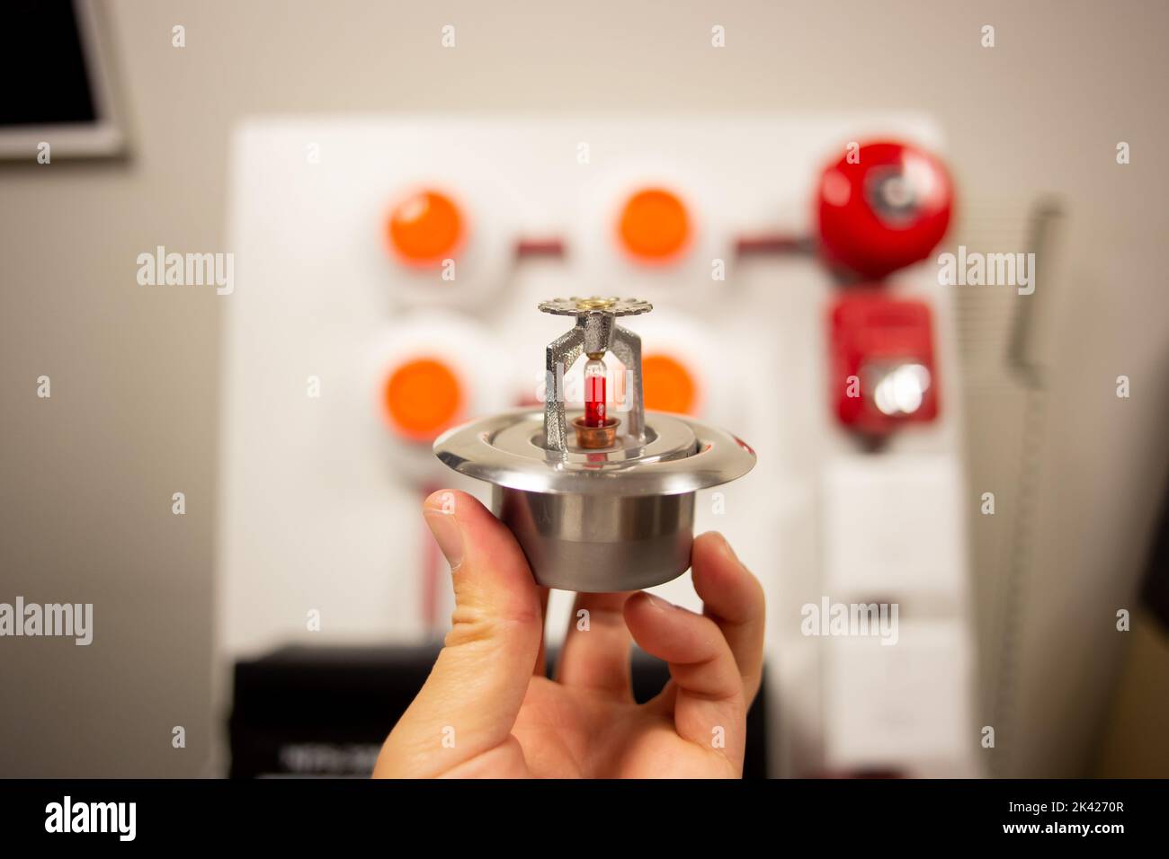 Fire alarm and mock sprinkler system attached to a white wall used for ...