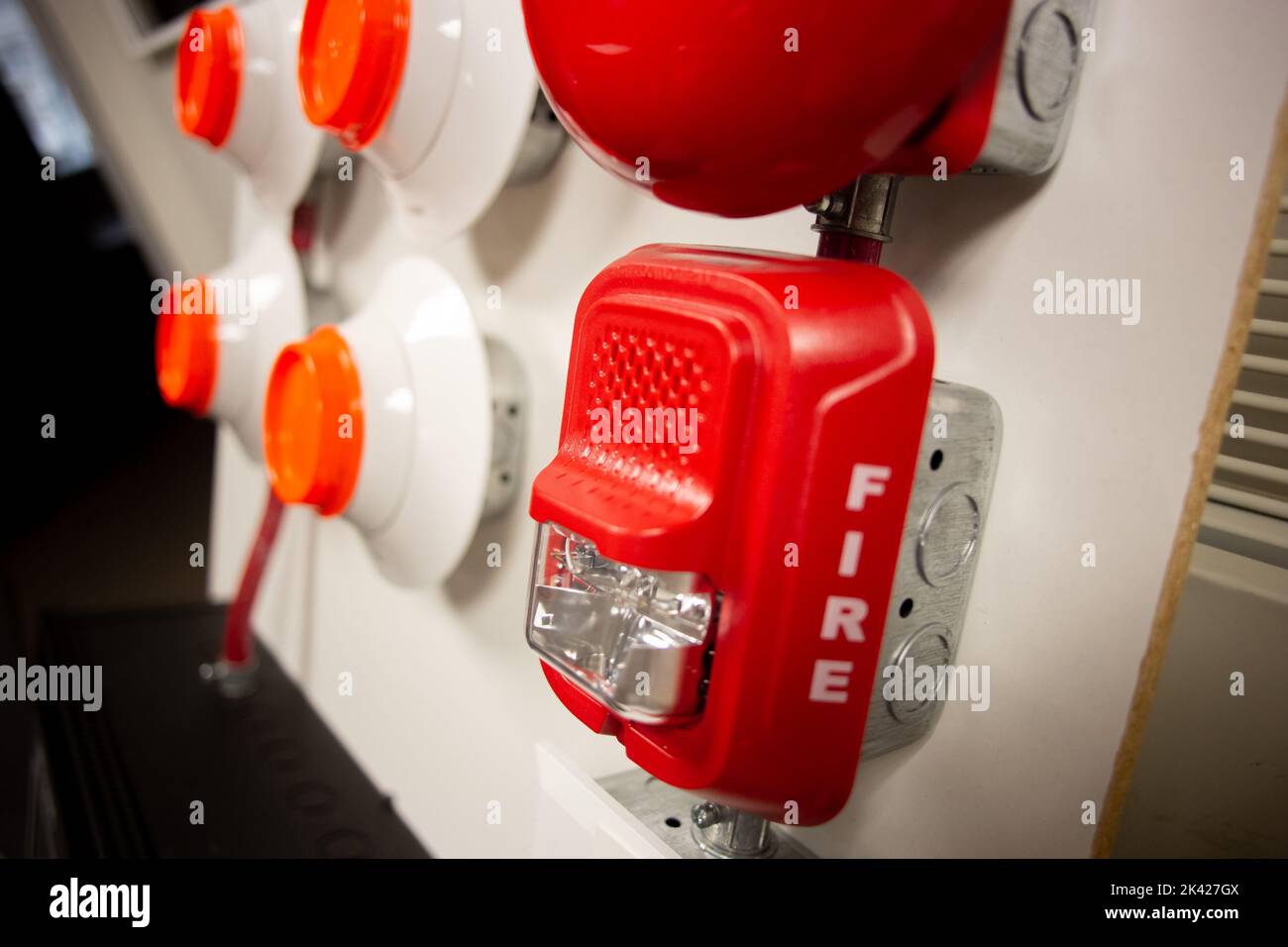 Fire alarm and mock sprinkler system attached to a white wall used for ...
