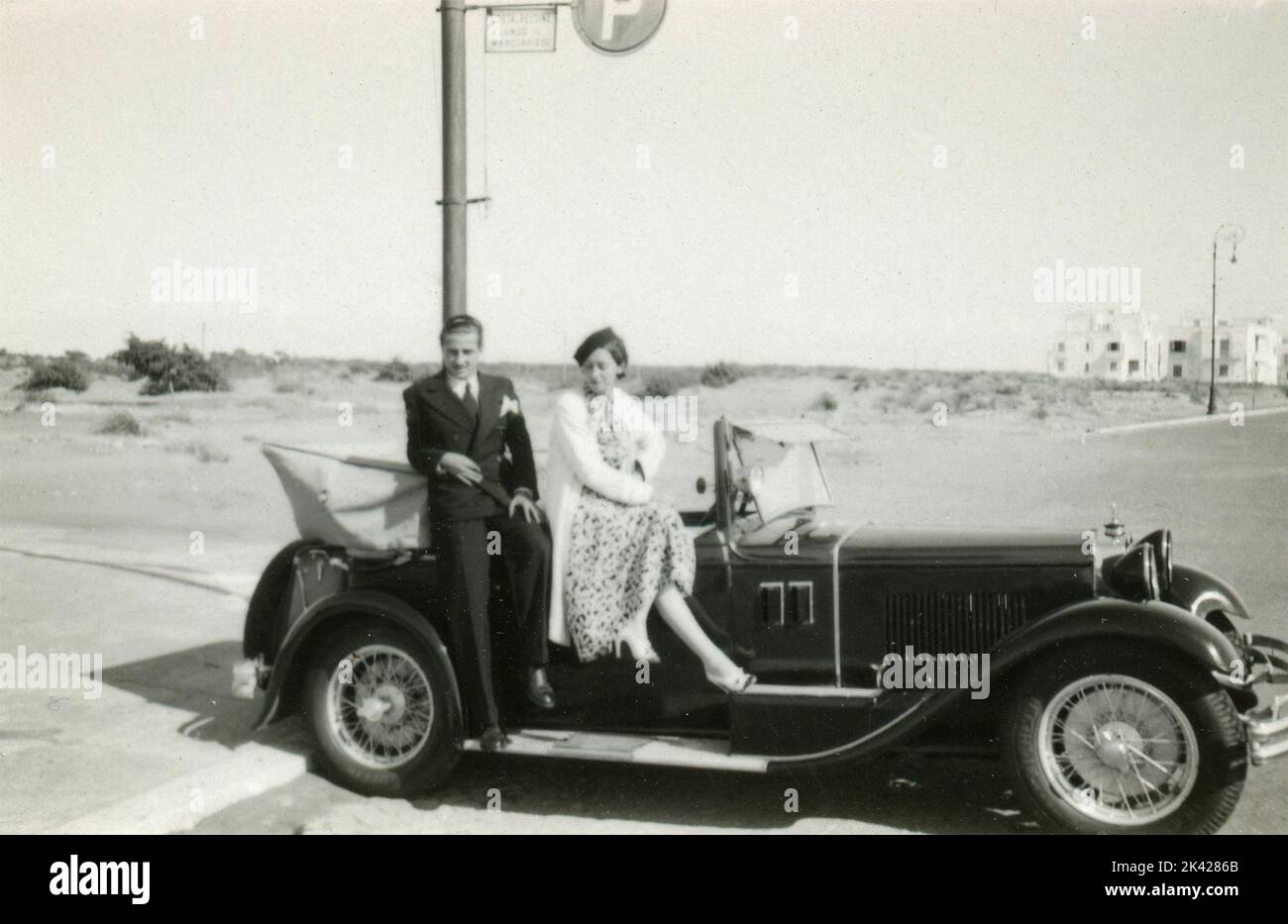 Couple with an old convertible car at the seaside in Ostia, Italy 1920s ...