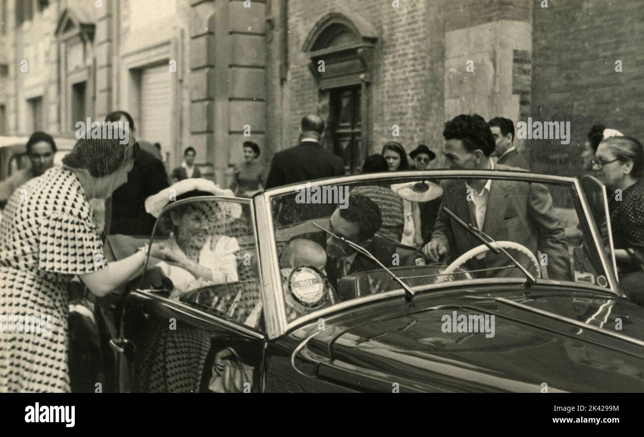 Just married couple inside a convertible car, Italy 1951 Stock Photo ...