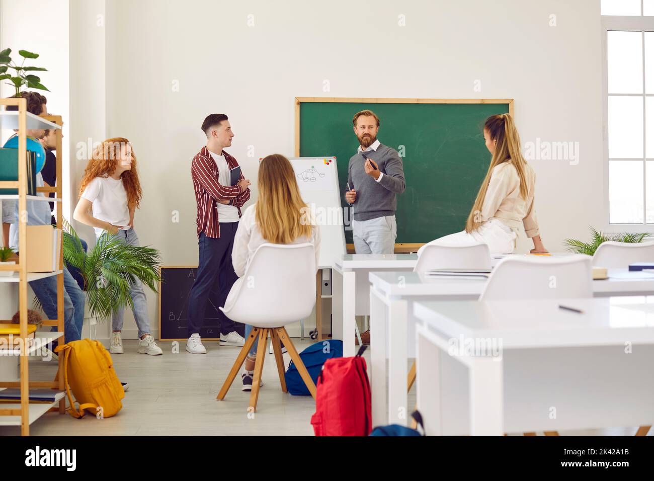 Teacher with whiteboard conducts lesson for students, explaining ...