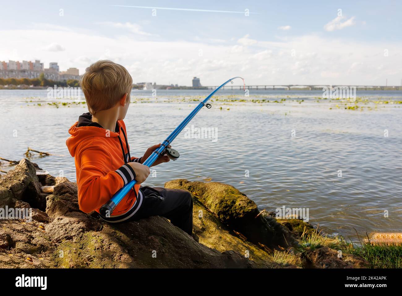 the boy is trying to pull the fish out of the river with the help of a ...