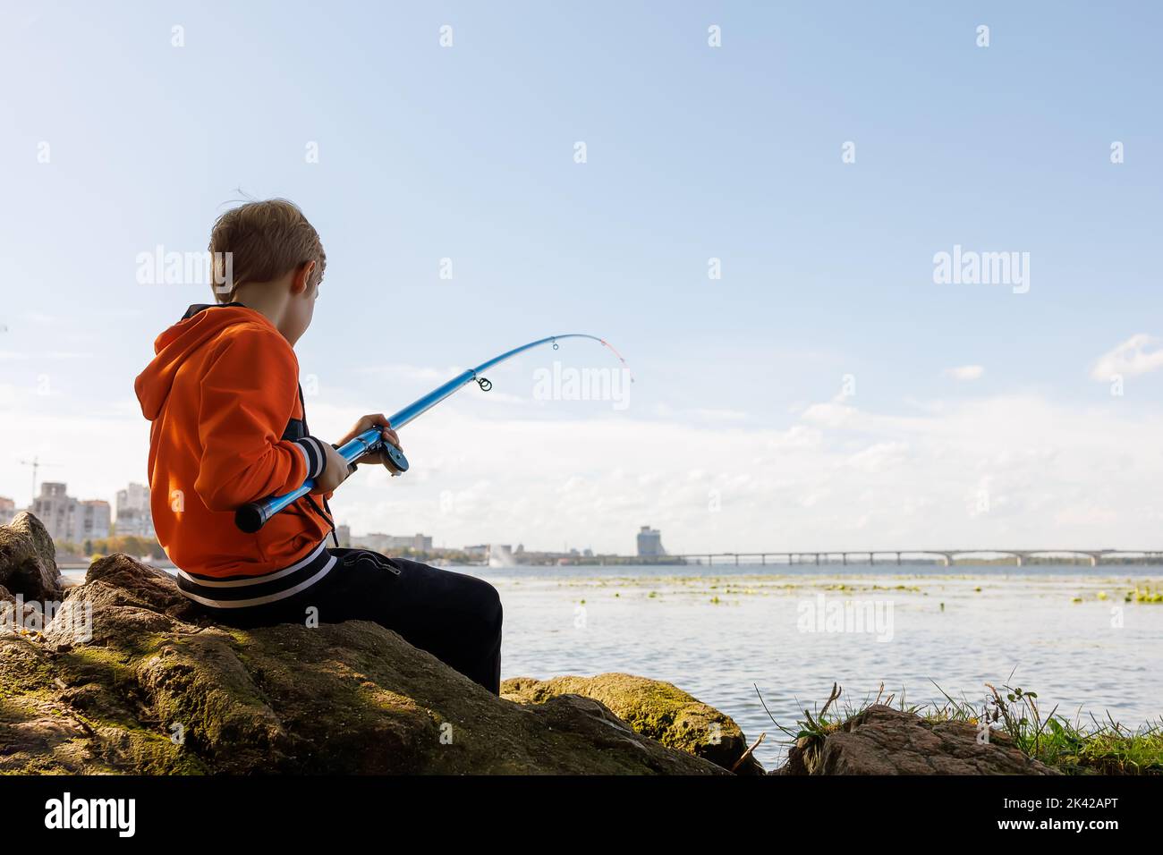the boy is trying to pull the fish out of the river with the help of a ...
