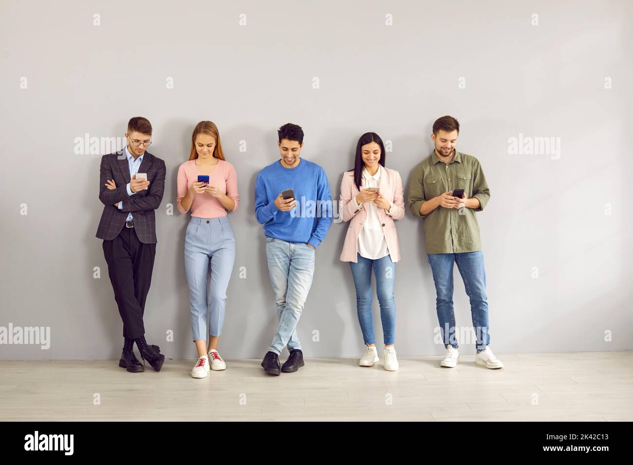 People standing in row having fun chatting on social networks without ...