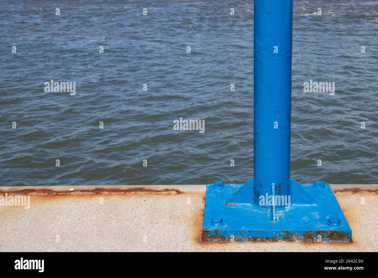 Blue pole at a dock with water in the background and copy space Stock ...