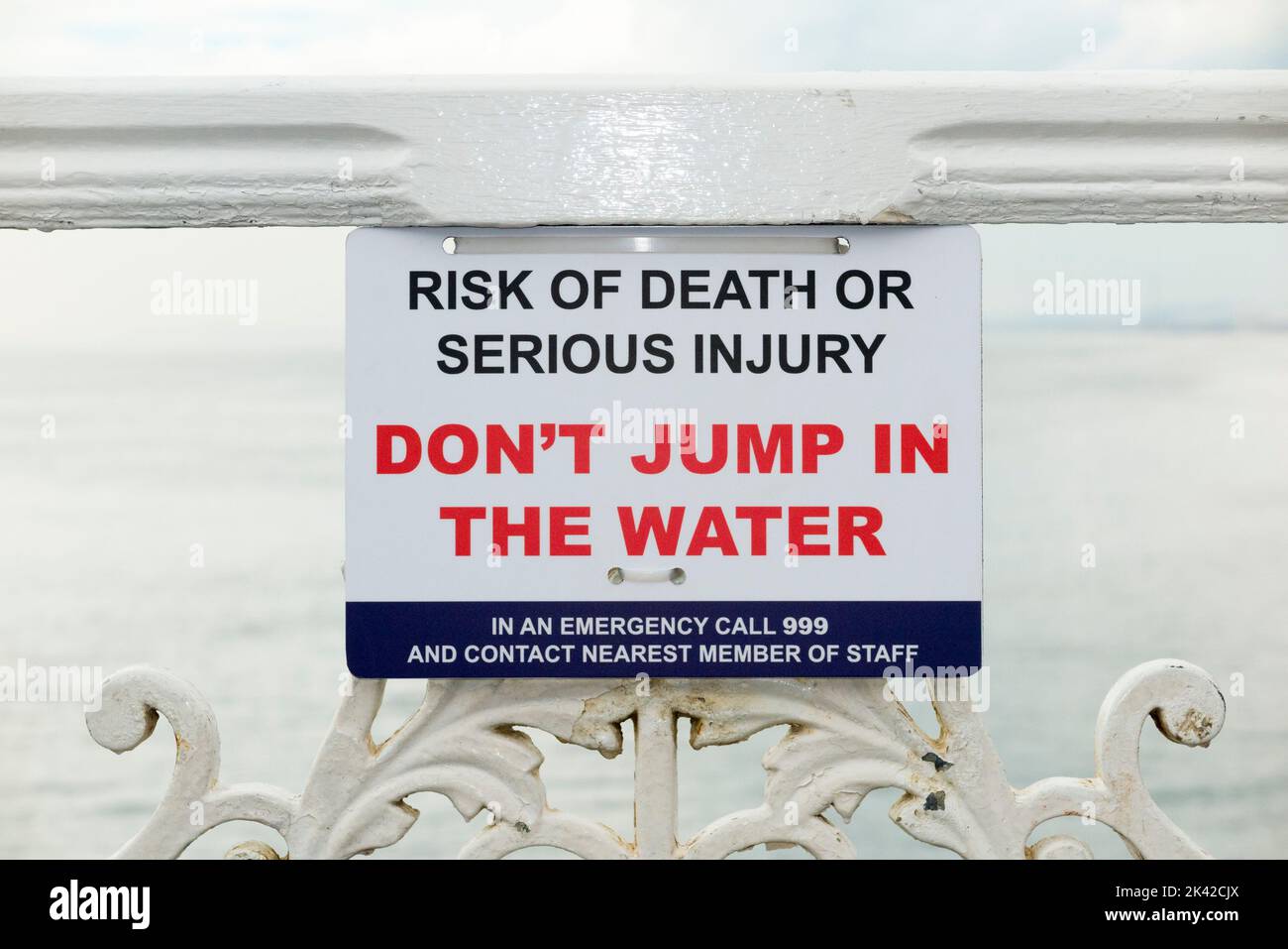 Safety notice sign telling people not to jump / no diving into the sea ...