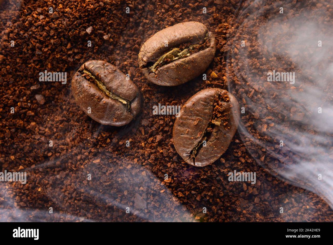 ground coffee and three beans in light smoke, place for writing and ...