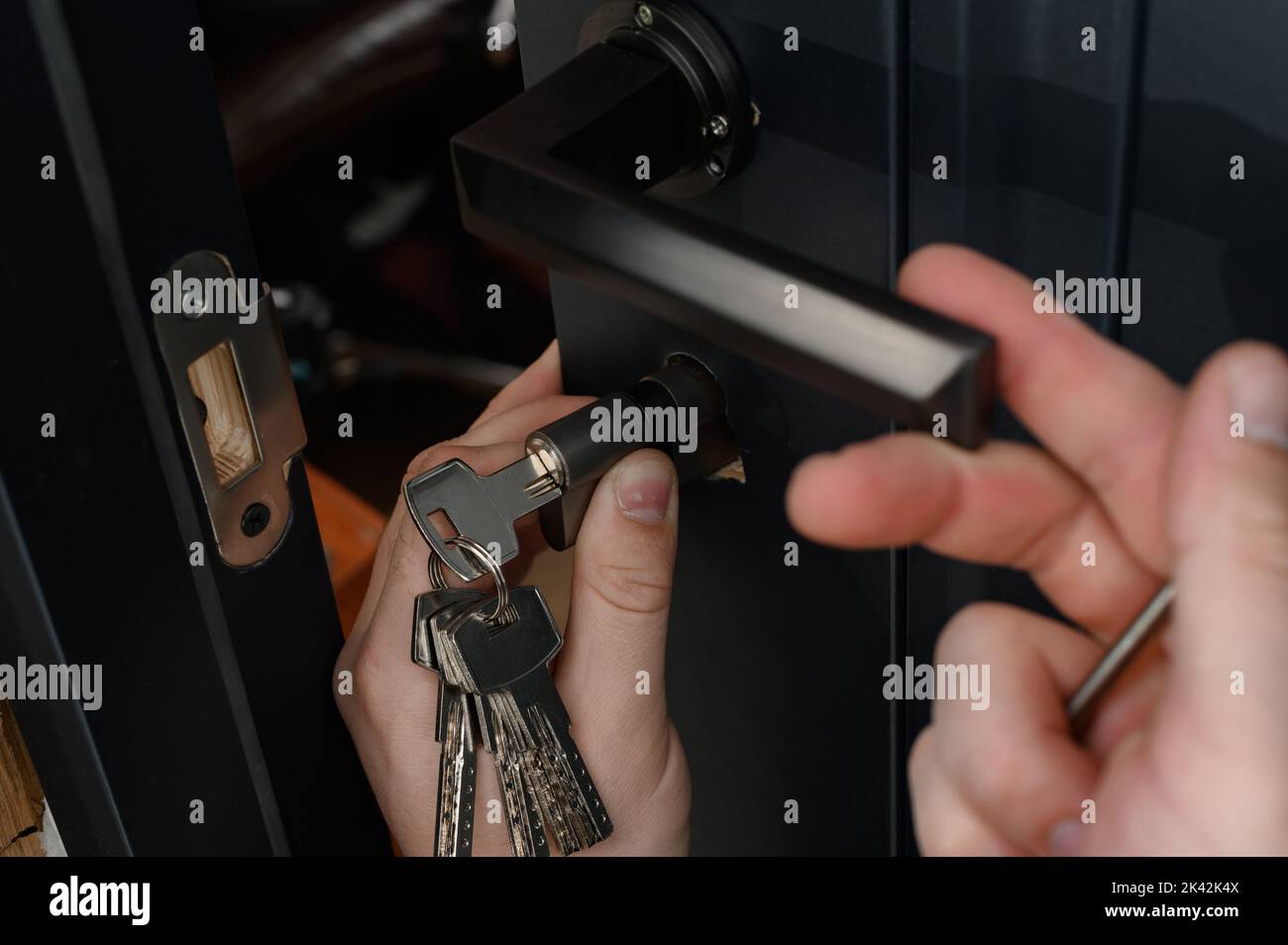 The master installs the core for the door lock, assembly work with the ...