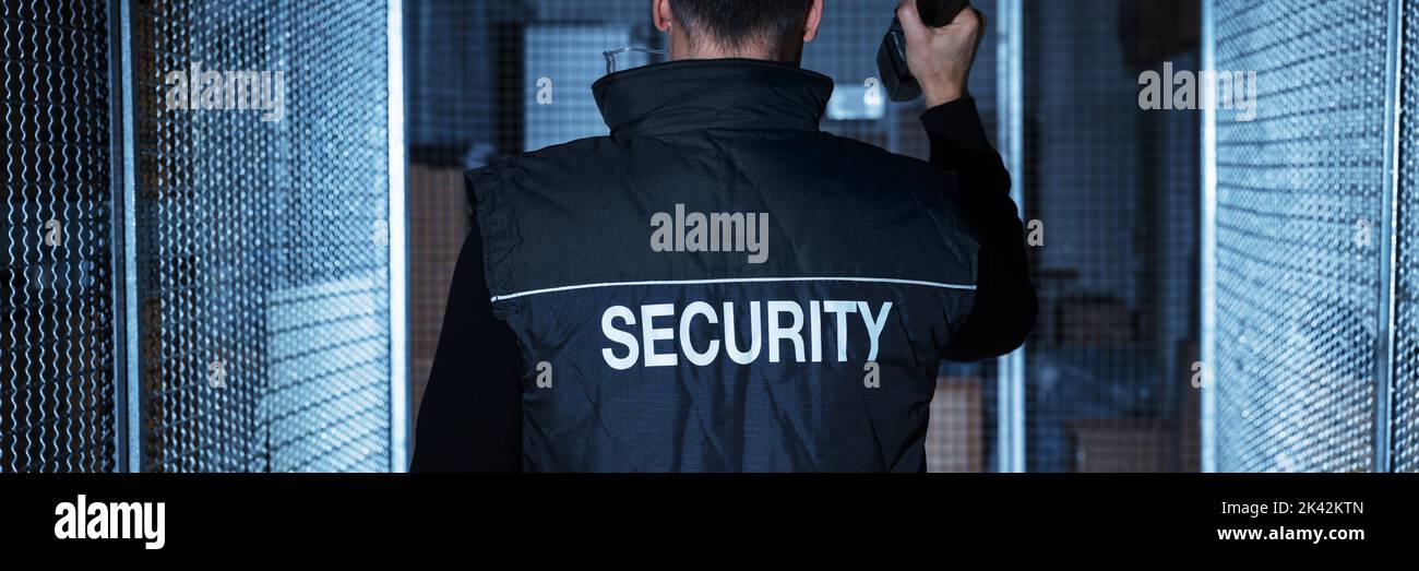 Security Guard With Flashlight At Night In Warehouse Stock Photo - Alamy
