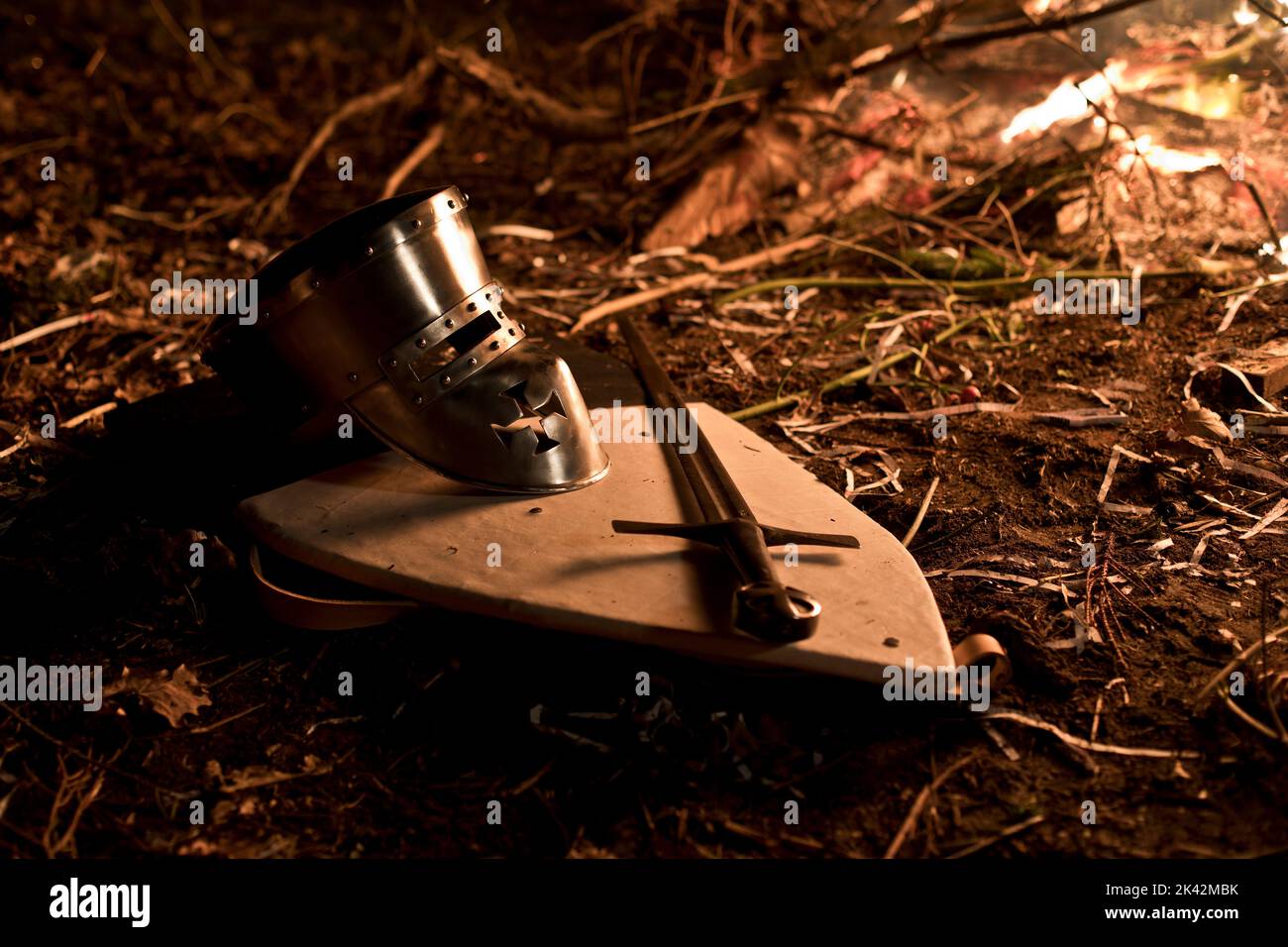 Sword, shield and helmet of a templar knight laying next to fire Stock ...