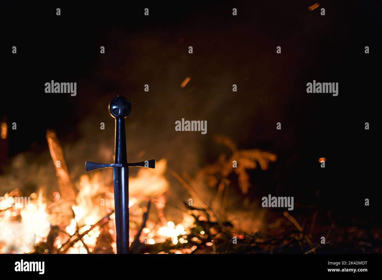 Close-up of Templar sword in ground by fire Stock Photo - Alamy