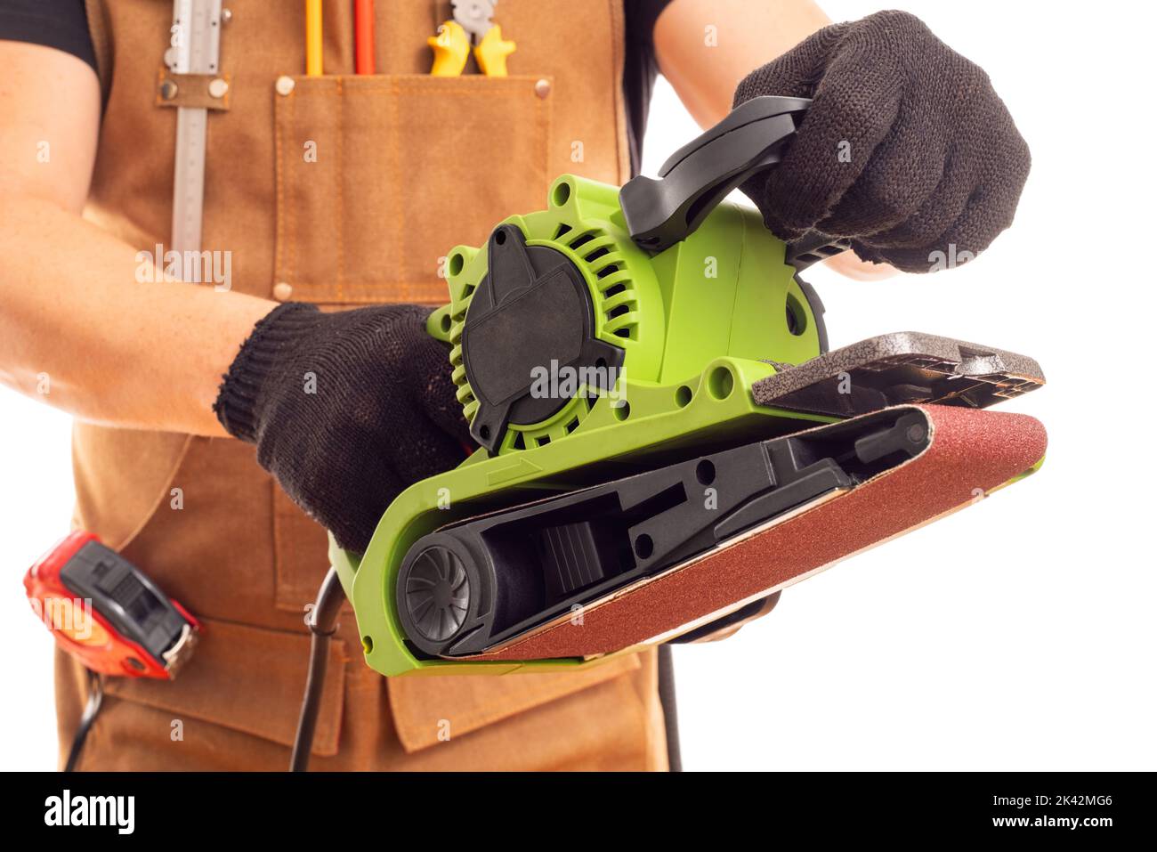Carpenter in workers apron holding belt electric sander on white ...