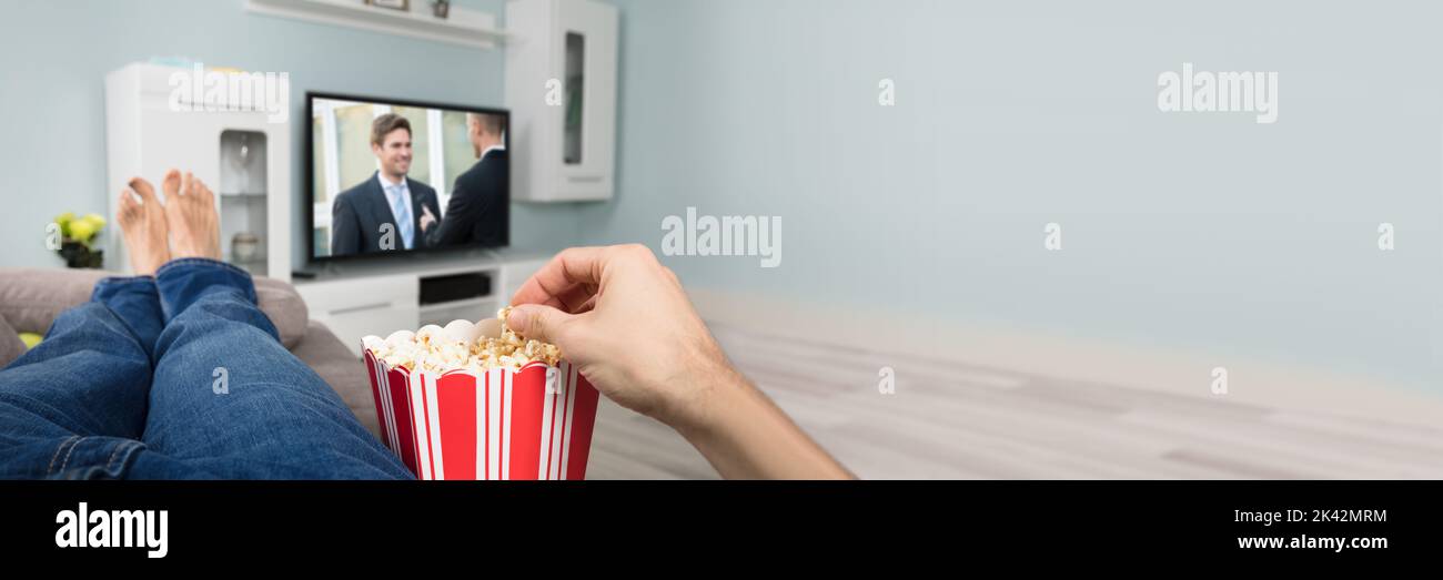 Eating Popcorn Watching TV On Sofa. Living Room Stock Photo - Alamy