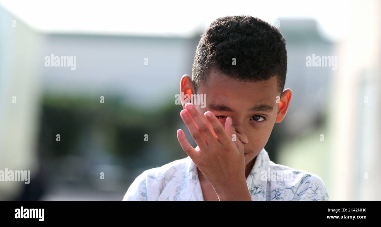 Child touching face with hand. kid touches nose itch Stock Photo - Alamy
