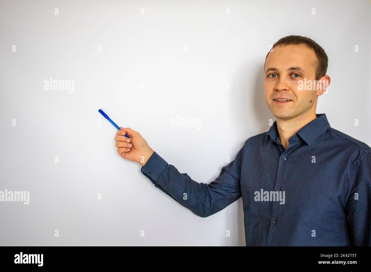 a handsome man stands at the white board and points with a pen. banner ...