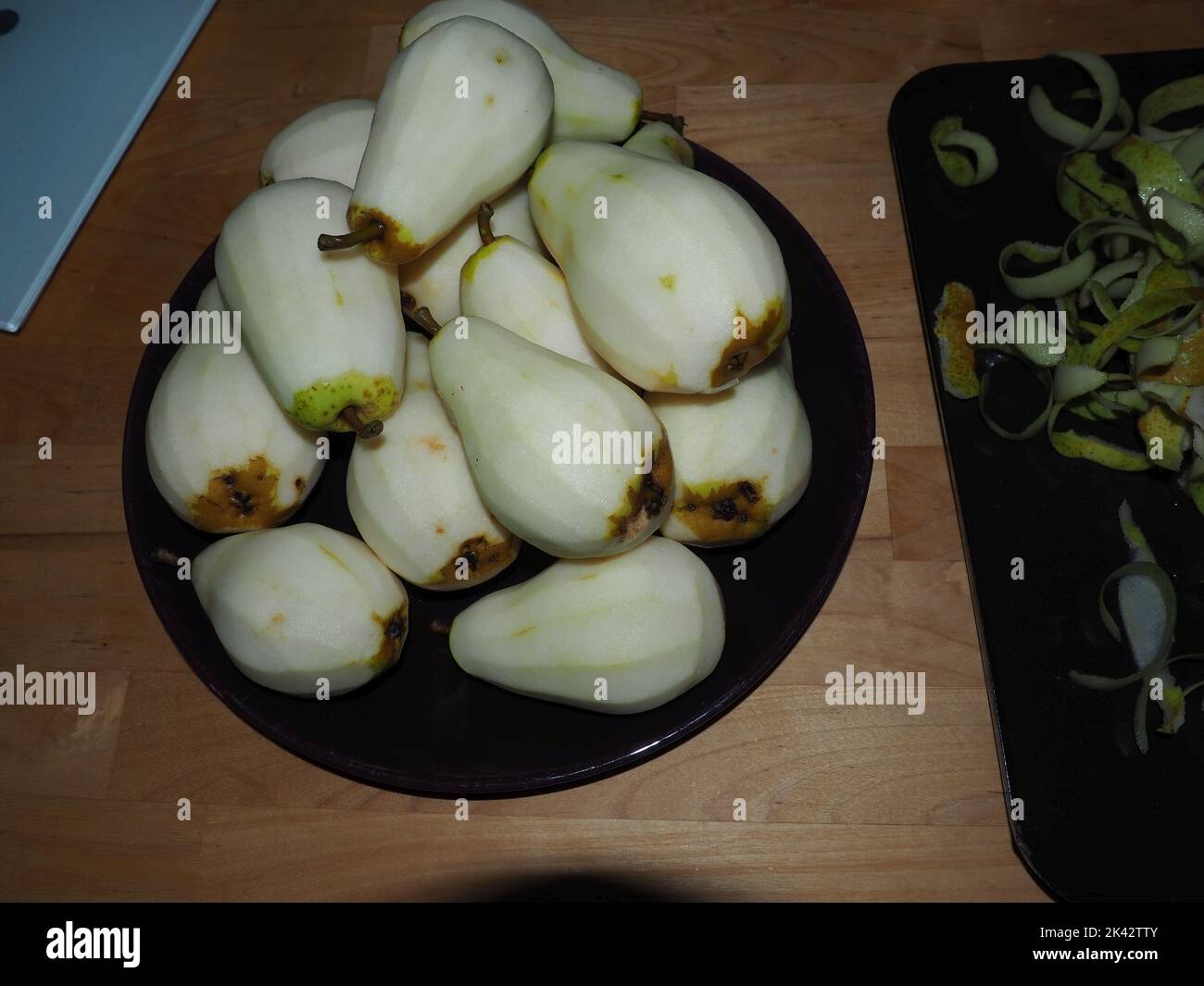 Pear preservation in process. Ripe fruit peeled on a metal tray and ...