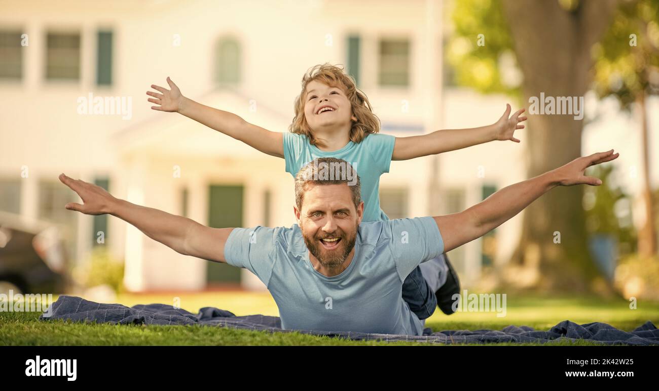parent relax with small child boy on grass. dad with kid on summer day ...