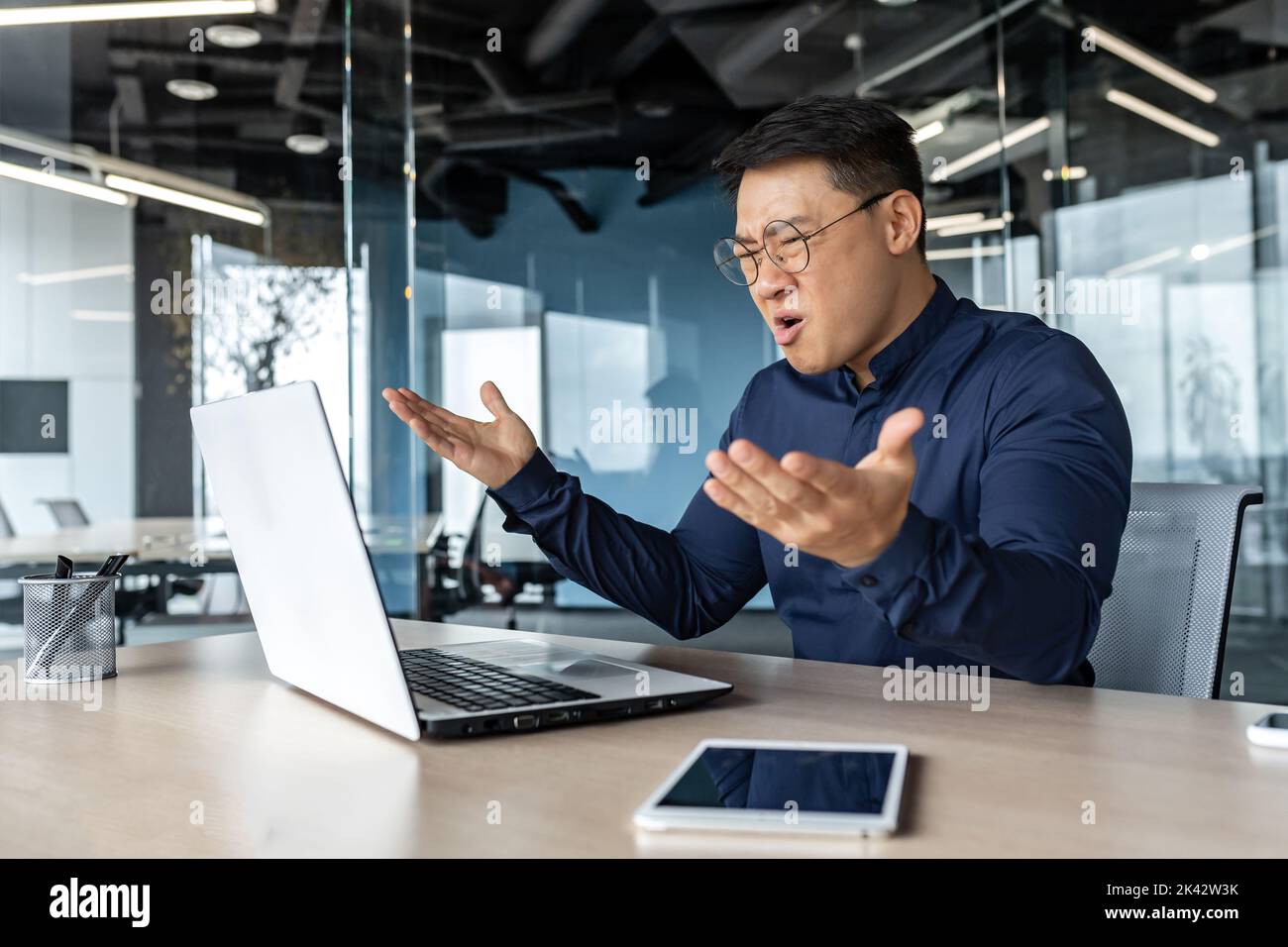 Frustrated and angry asian boss yelling at laptop, failure man working ...