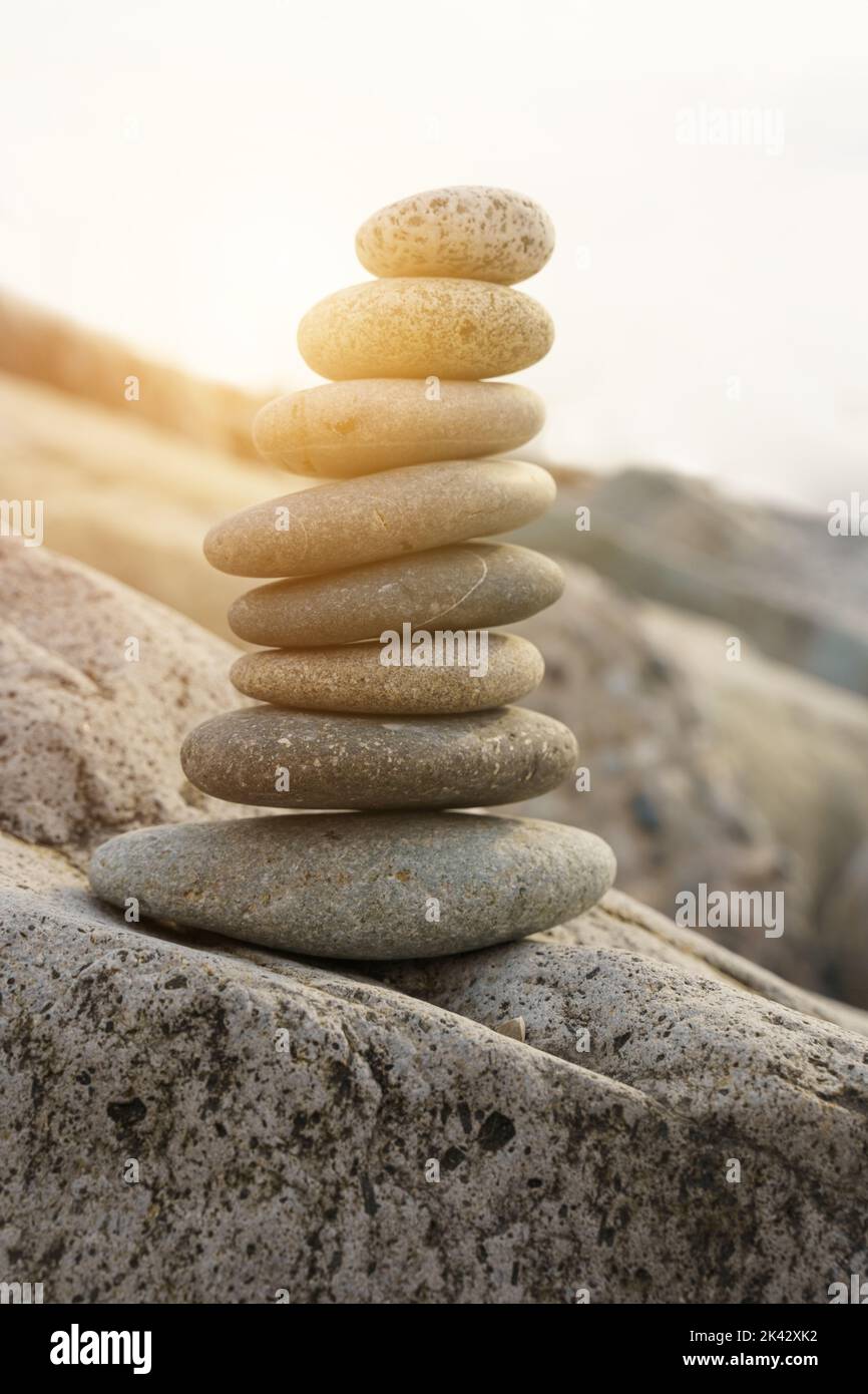 Pyramid stones balance on the beach in the sun. The concept of rest and ...