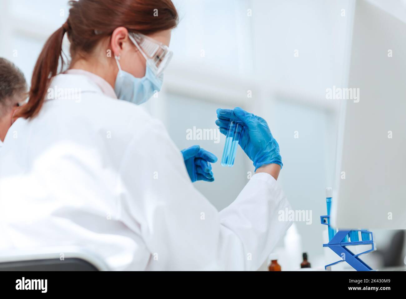 close up .female scientist looking at test tube Stock Photo - Alamy