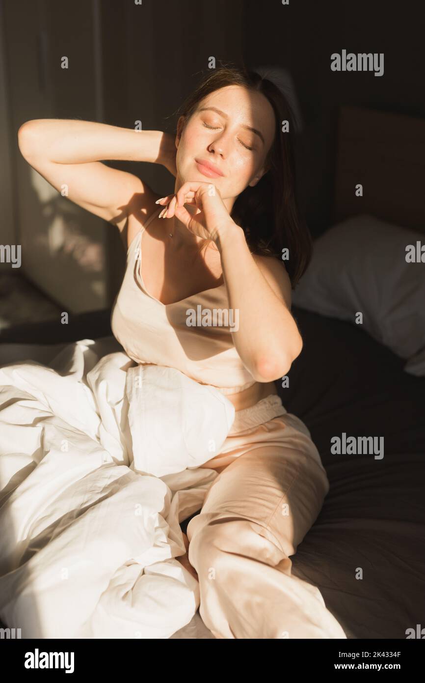 Girl Is Waking Up In Morning Stretches In Bed And Sun Shines From The