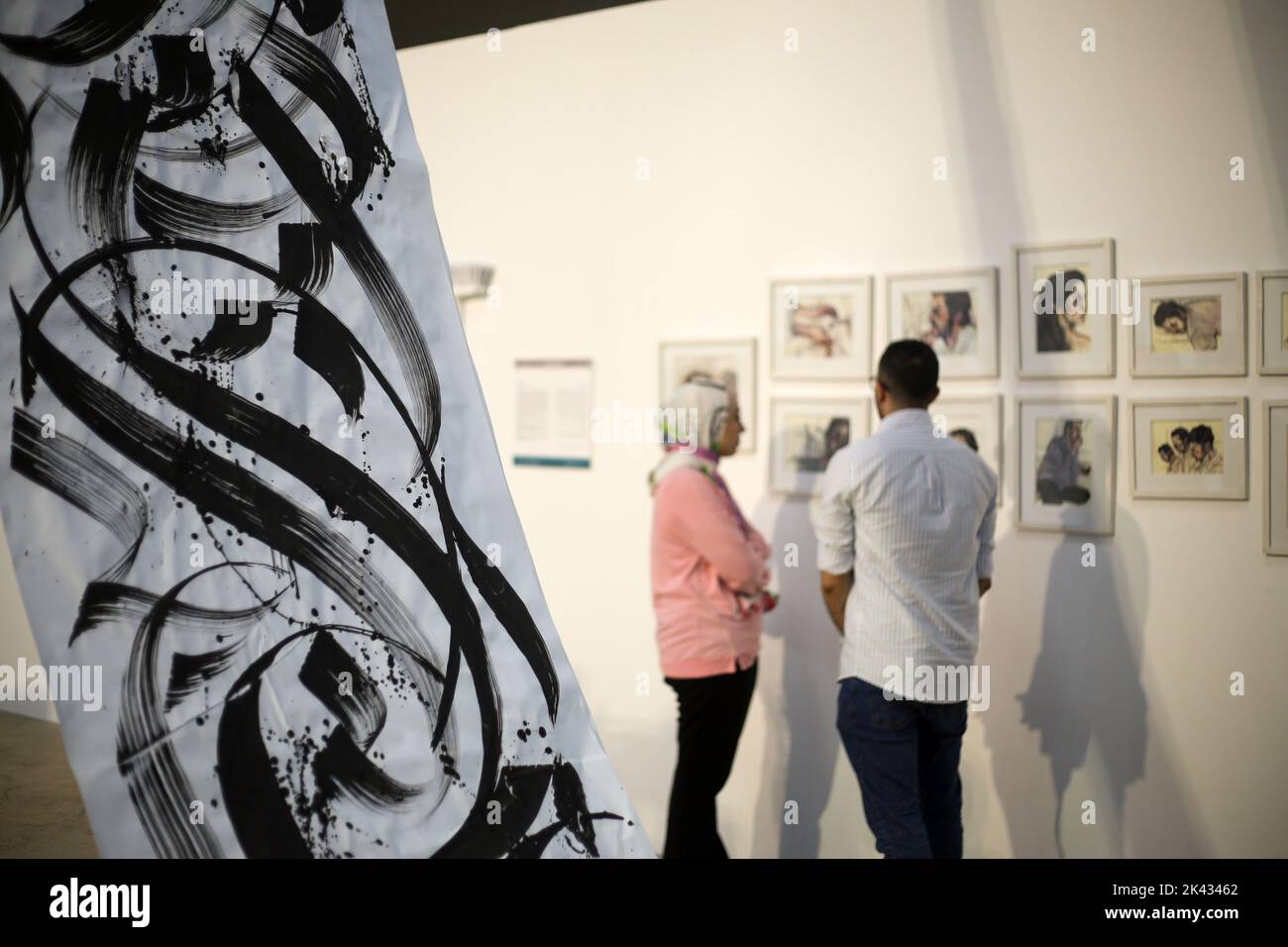 Palestinians look at the artworks during a contemporary art exhibition ...