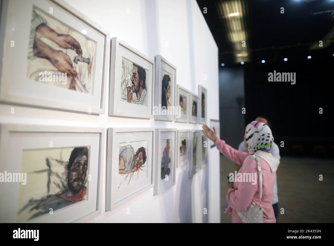 Palestinians look at the artworks during a contemporary art exhibition ...