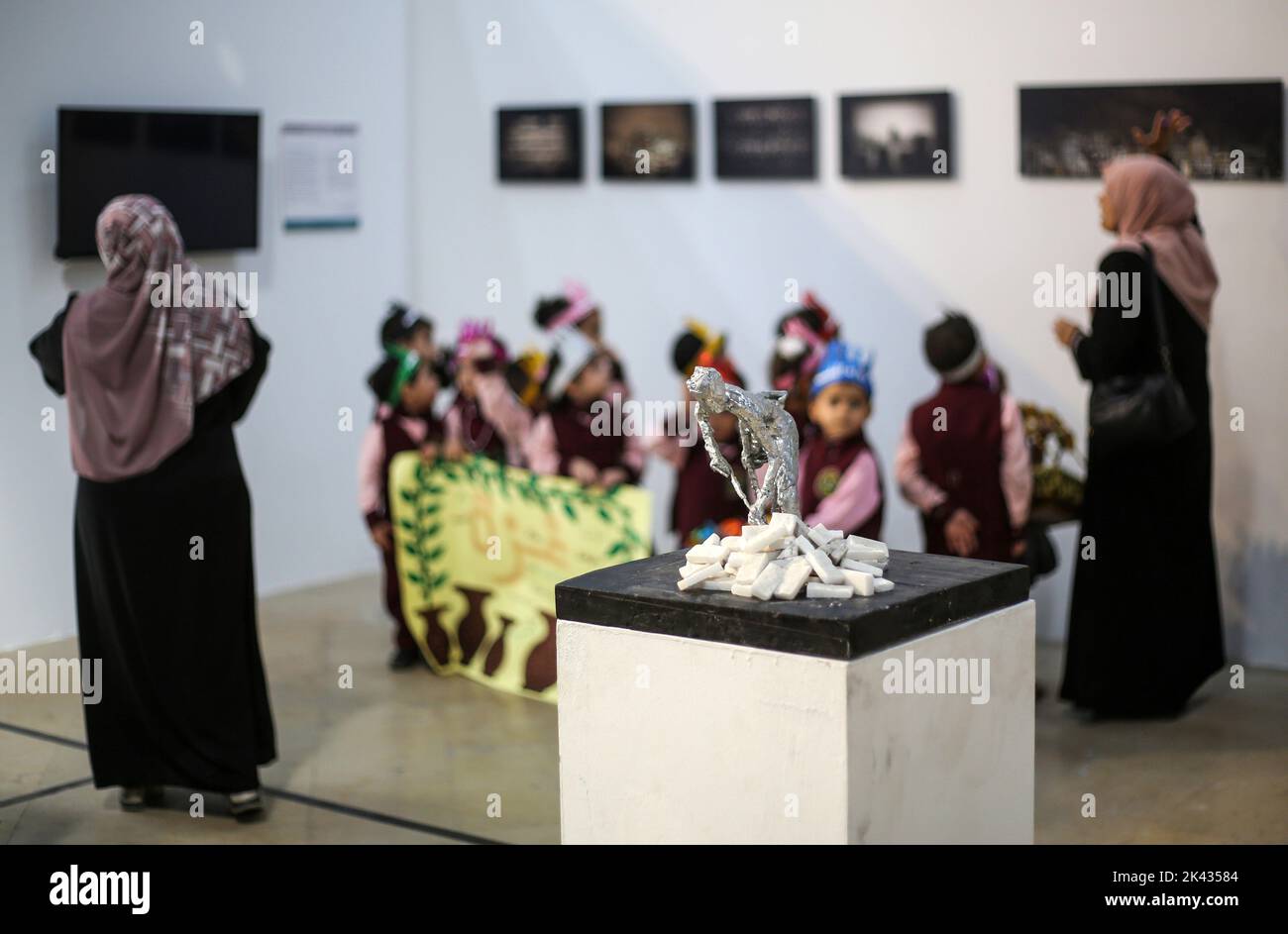 Palestinians look at the artworks during a contemporary art exhibition ...