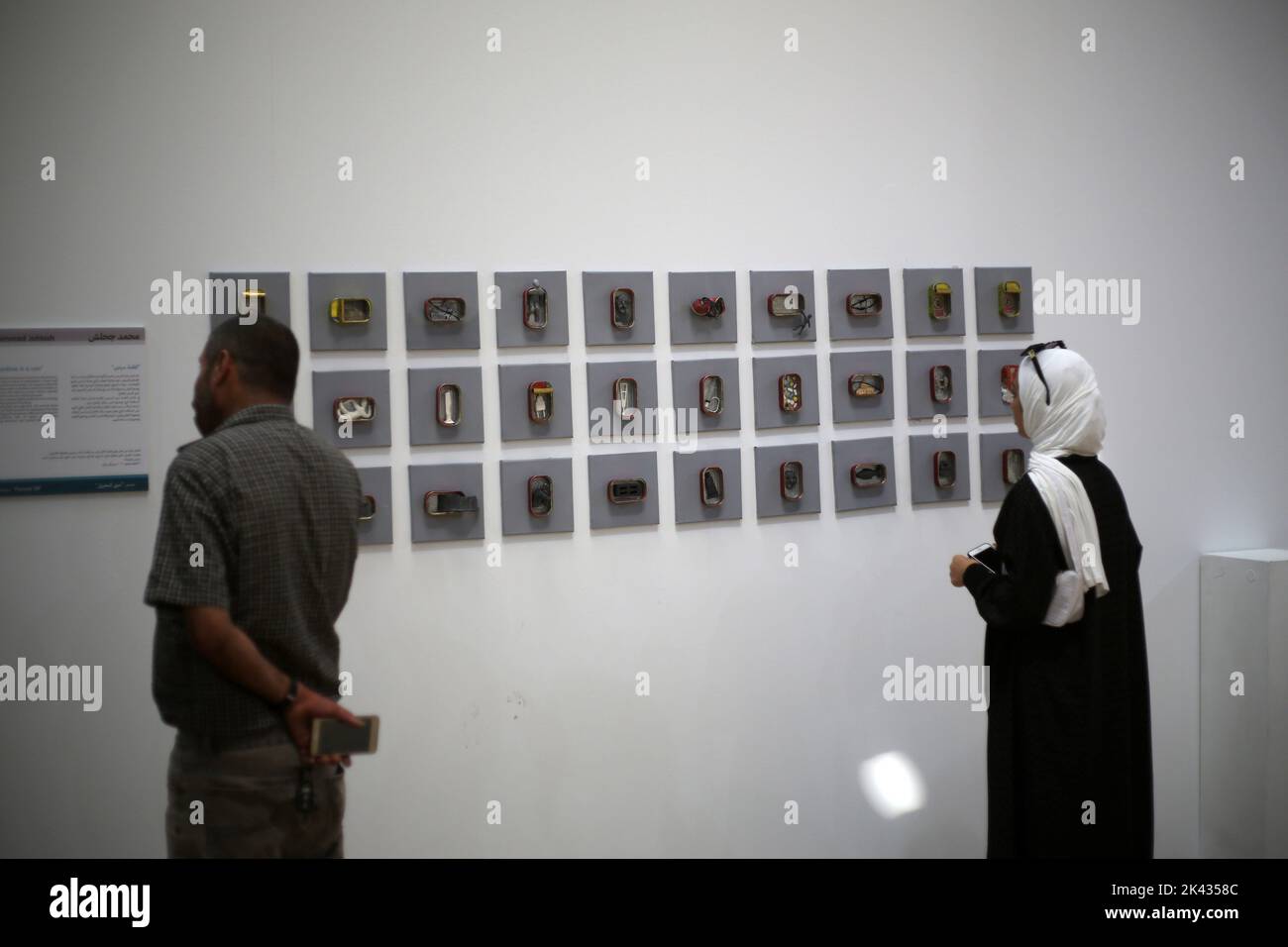 Palestinians look at the artworks during a contemporary art exhibition ...