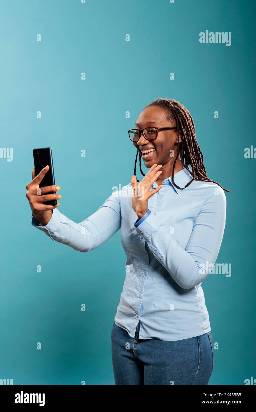 Beautiful confident young lady greeting friend over online phone video ...