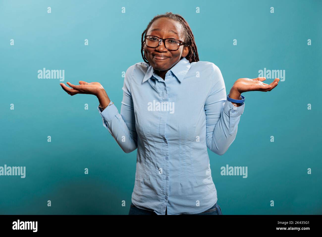 Confused and uncertain woman shrugging shoulders with uncertainty while ...