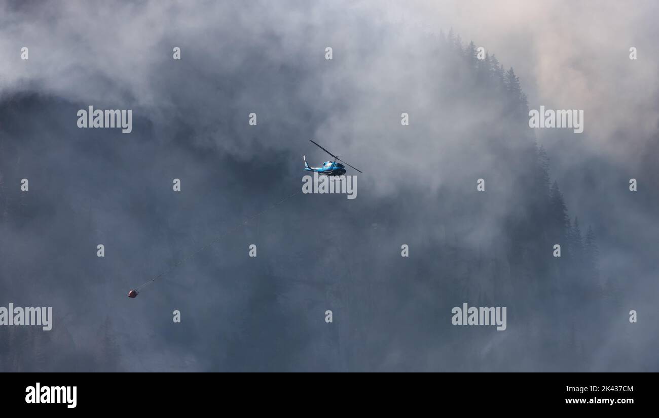 Wildfire Service Helicopter flying over BC Forest Fire and Smoke on the ...