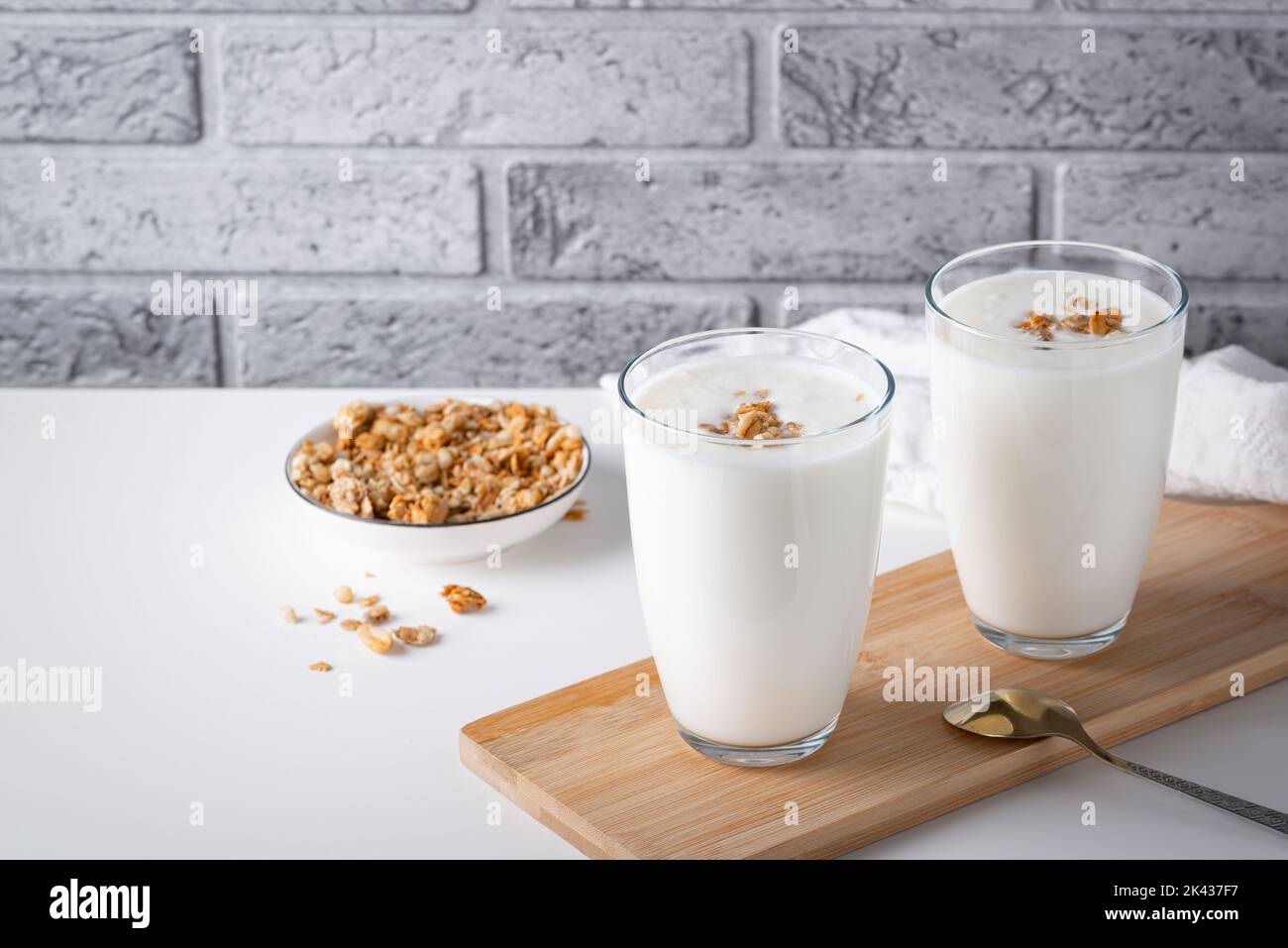 Kefir, buttermilk or yogurt with granola. Yogurt in glass on light ...