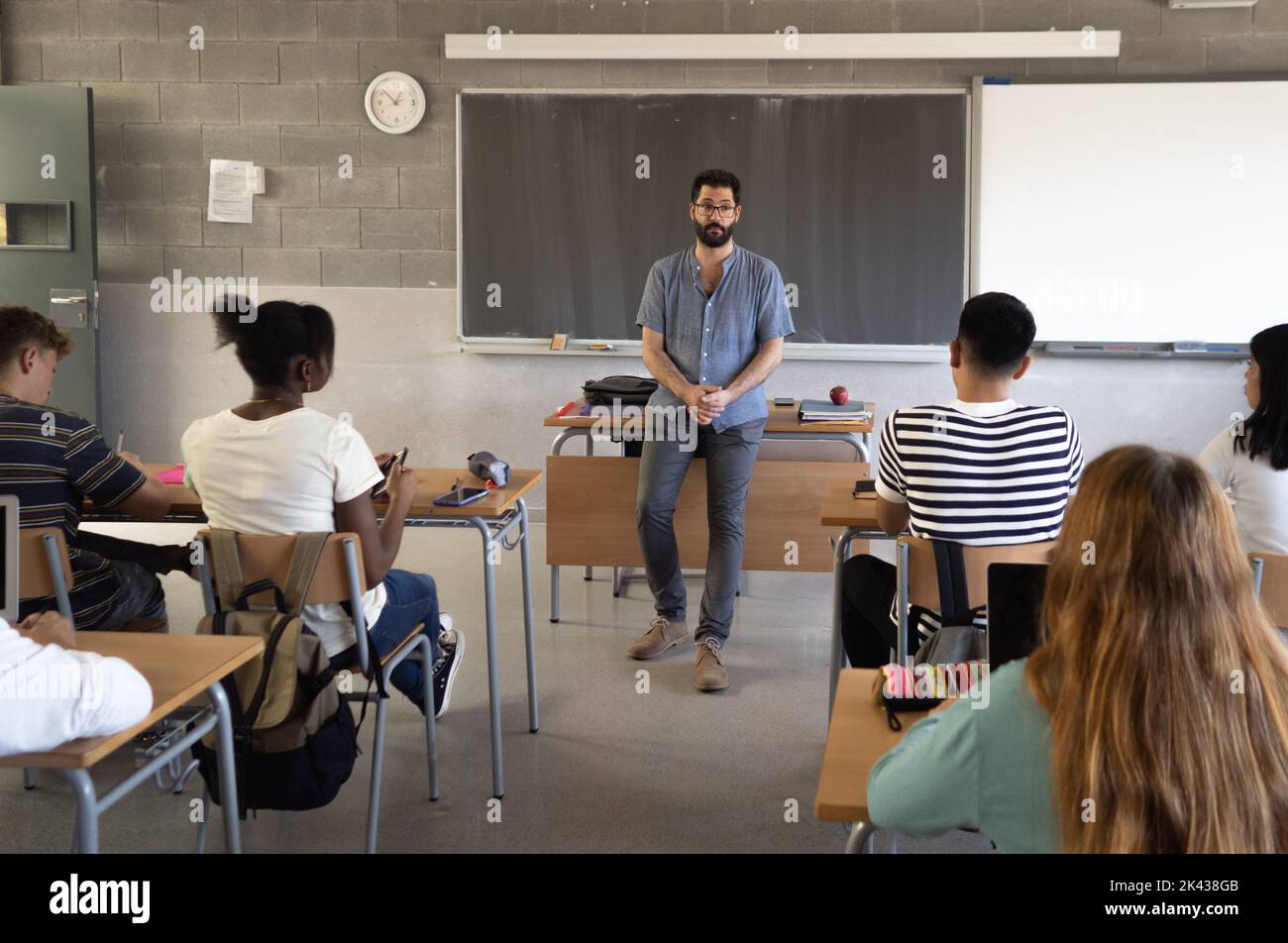 Male teacher explaining the class lesson in a classroom Stock Photo - Alamy