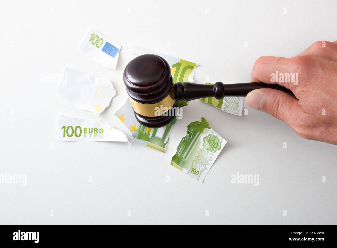 Hand with gavel breaking bank note on white table. Financial judgment ...
