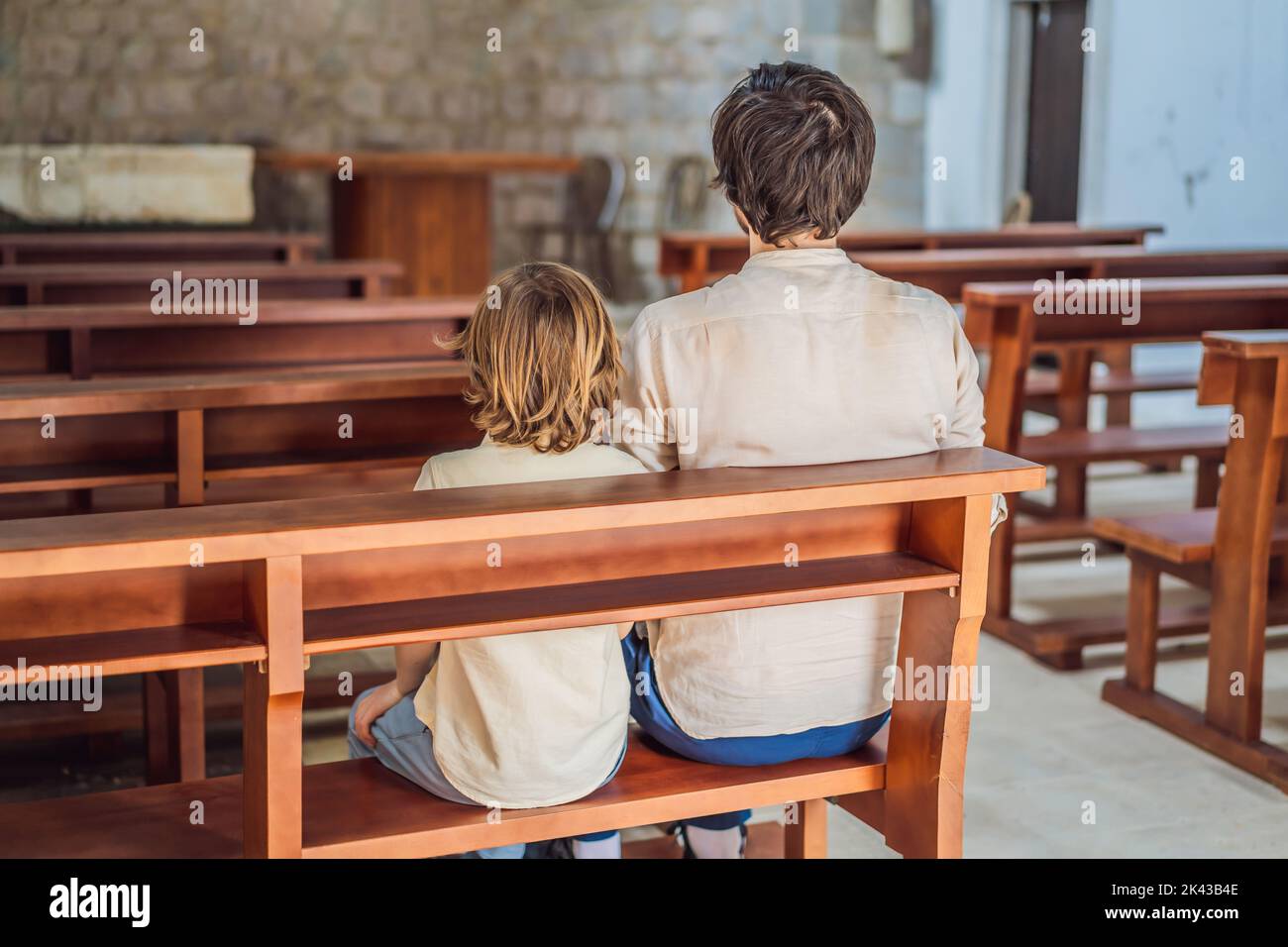 Christian dad tells his son Bible stories about Jesus sitting in kirk ...