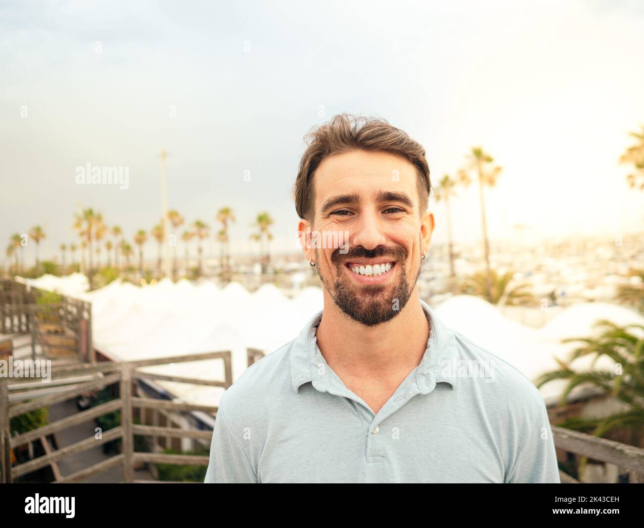 Smiling young spanish man looking at the camera during a sunset with ...