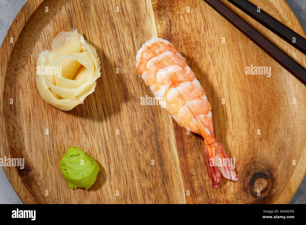 raw red shrimp nigiri photographed from above on wooden cutting board ...