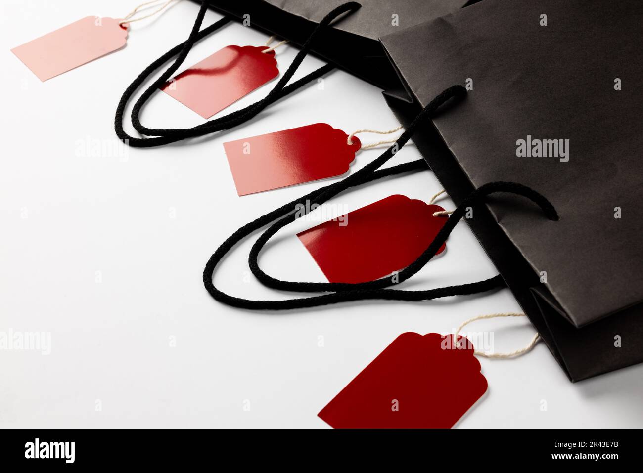 Composition of gift tags and bags with copy space on white background ...