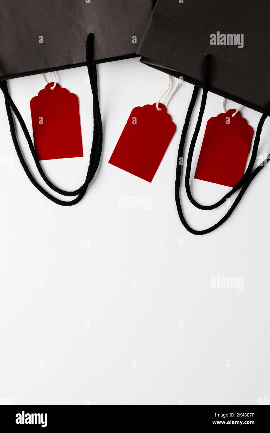 Composition of gift tags and bags with copy space on white background ...