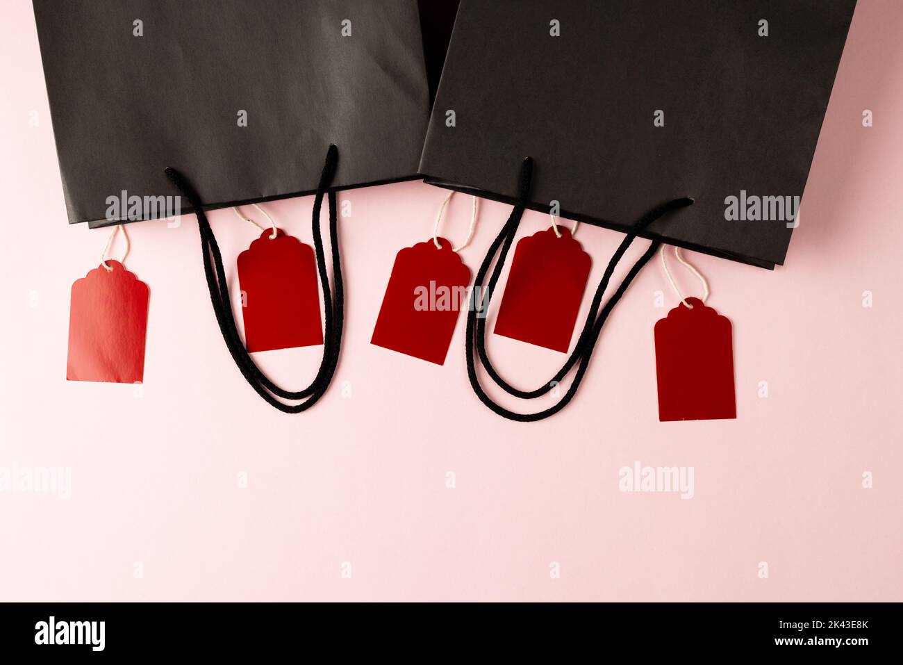 Composition of gift tags and bags with copy space on white background ...