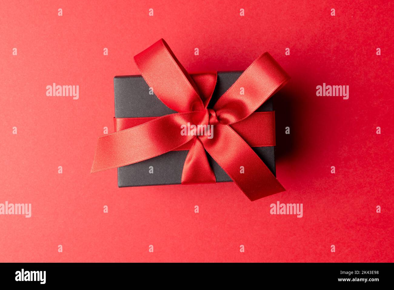 Composition of present with red ribbon on red background Stock Photo ...