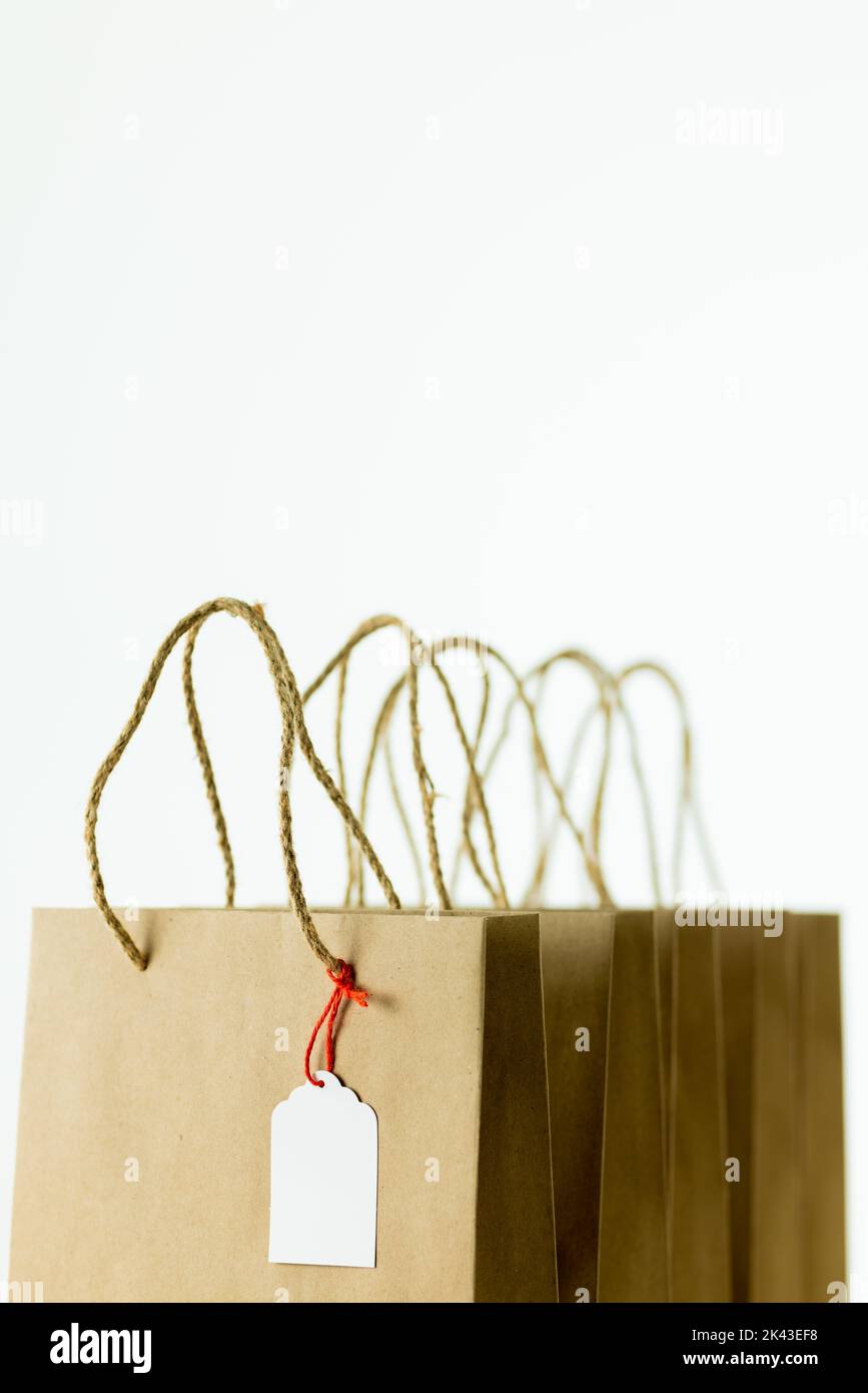 Composition of gift tag and paper shopping bags on white background ...