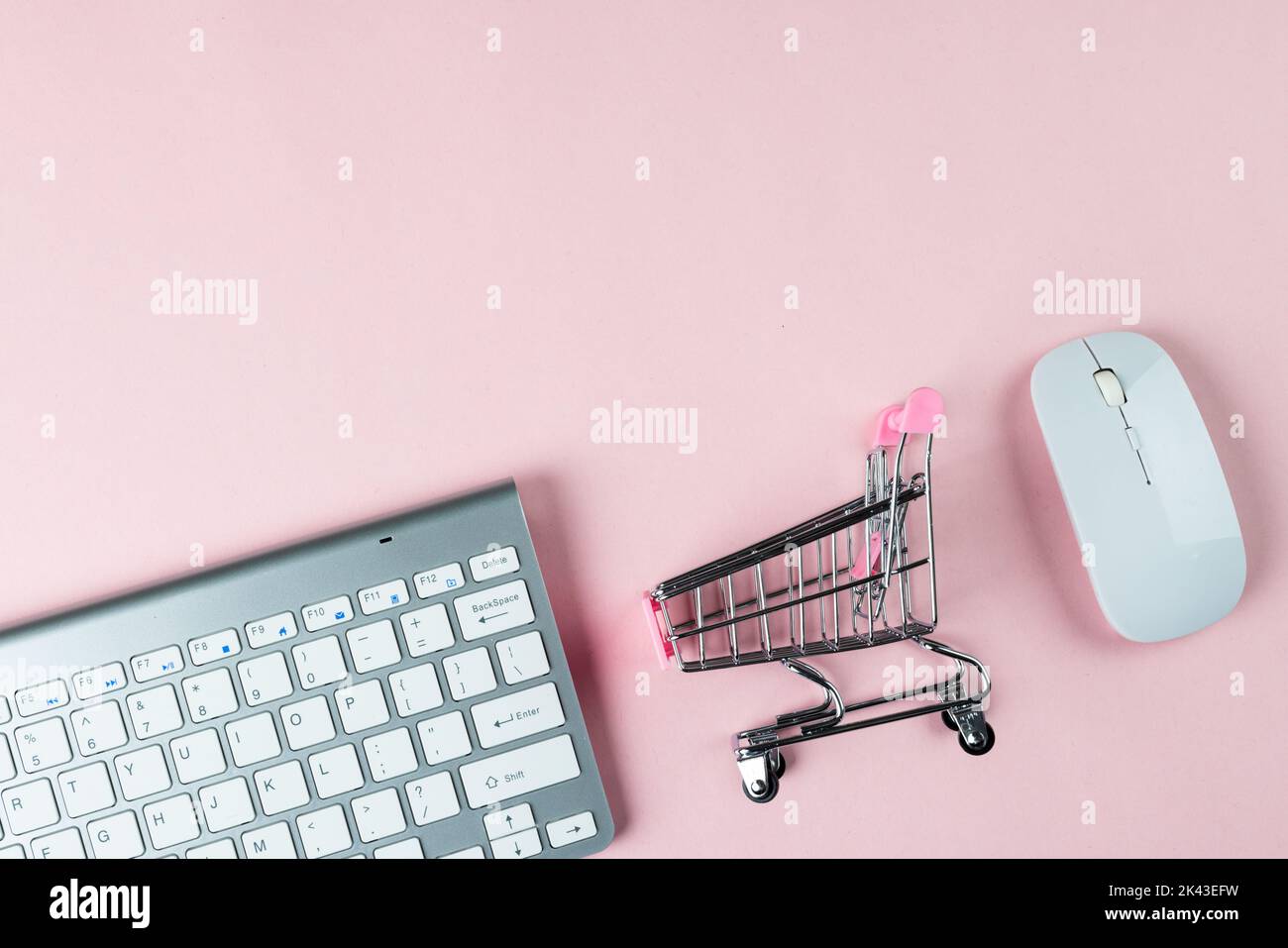 Composition of keyboard, mouse and shopping cart on white background ...