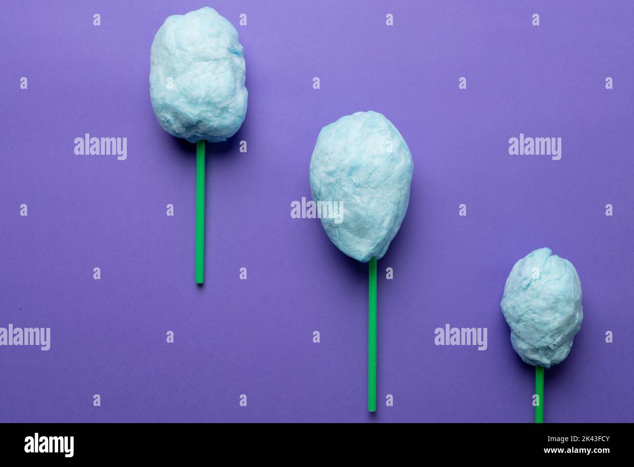 Horizontal image of homemade blue candy floss on three sticks, on ...