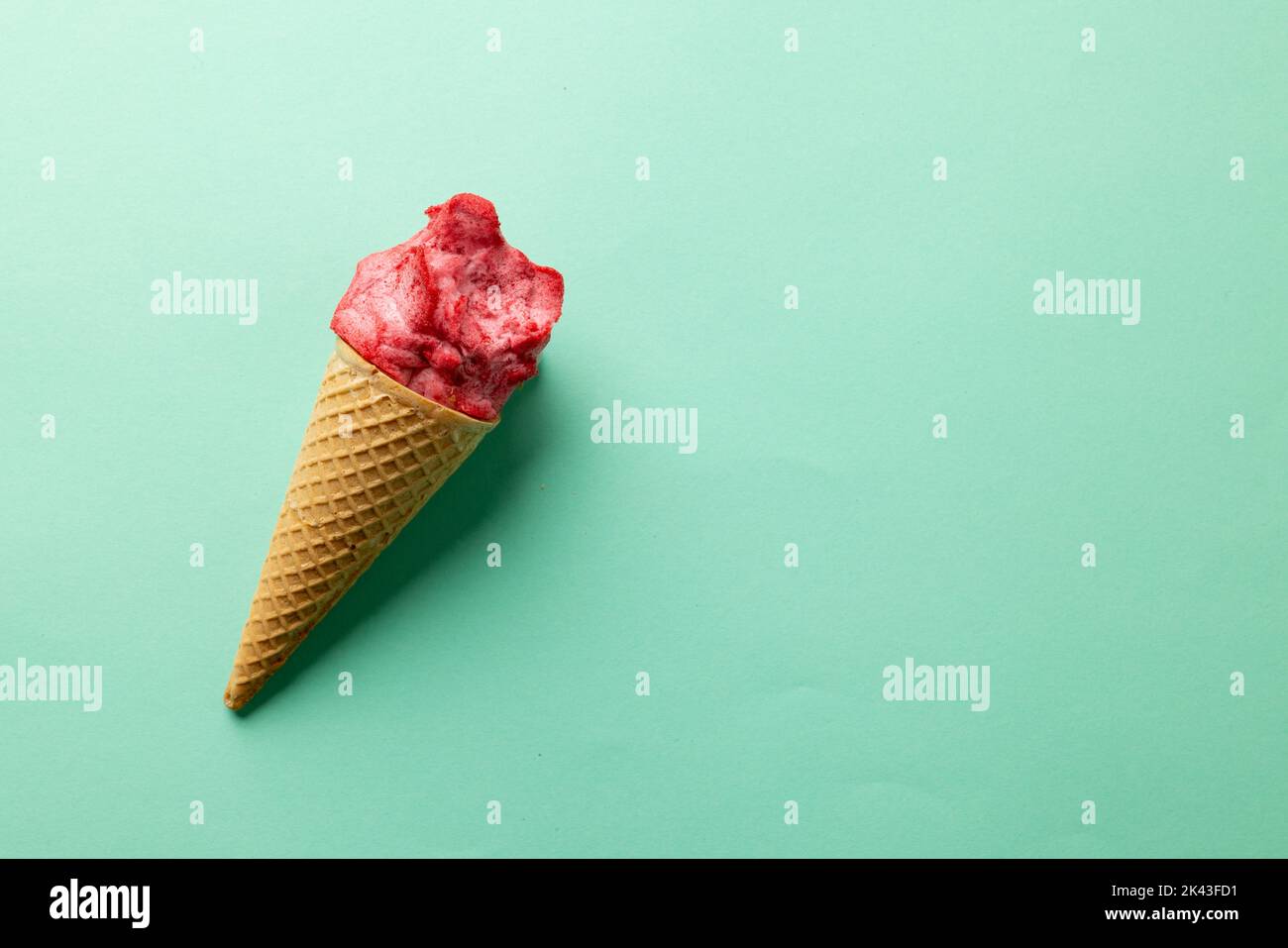 Horizontal image of home made strawberry ice cream in cone, on blue ...