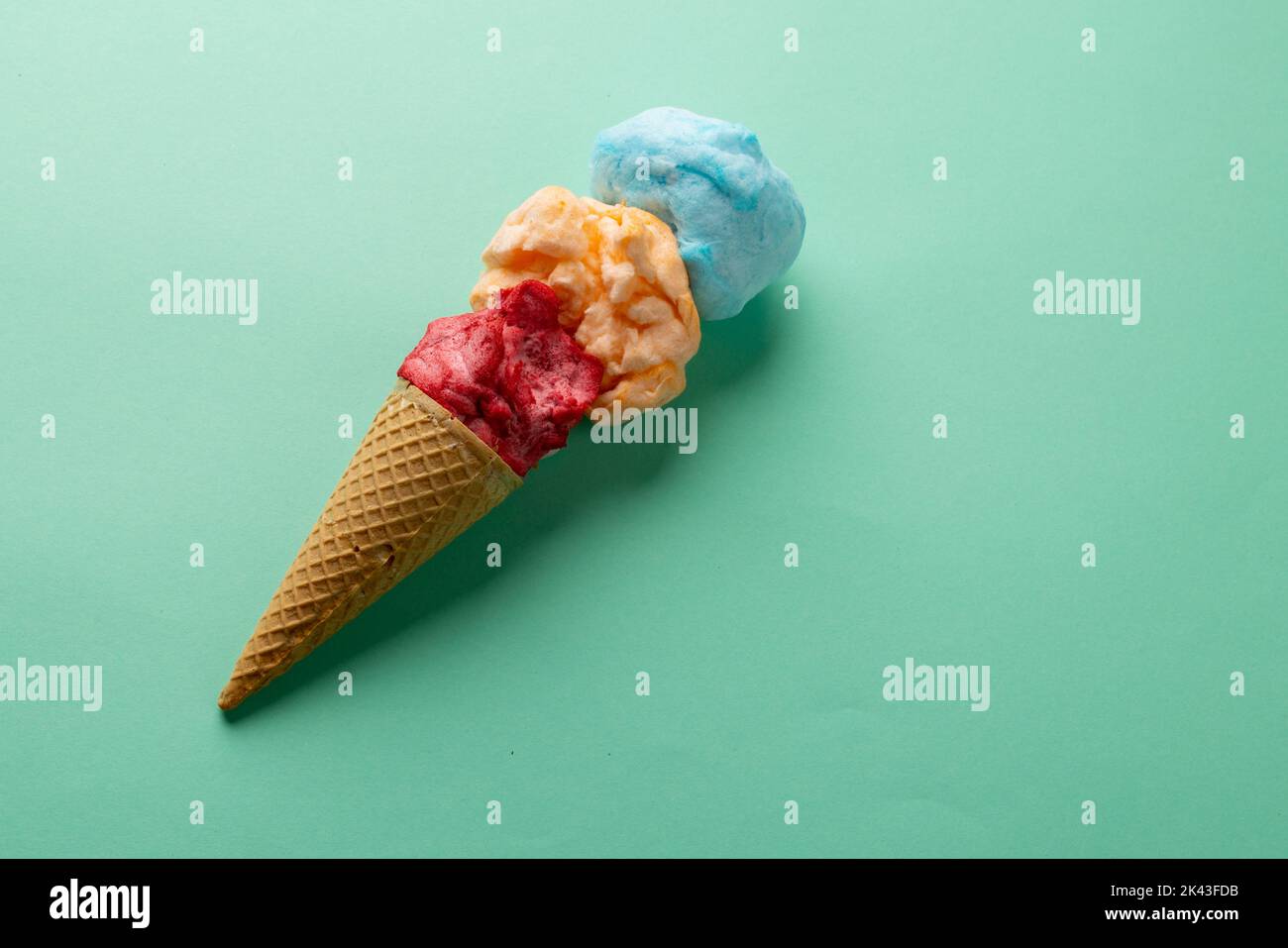 Horizontal image of three coloured flavours of ice cream in cone, on ...