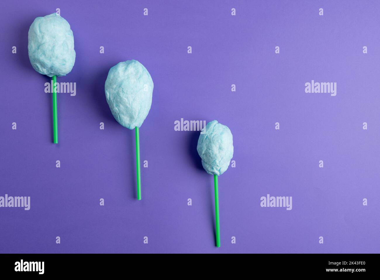 Horizontal image of homemade blue candy floss on three sticks, on ...