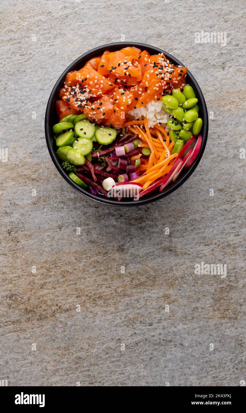 Overhead view of hawaiian poke bowl with copy space on grey background ...
