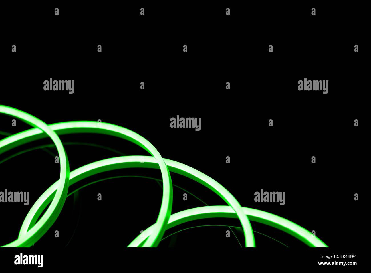 Image of vibrant spiral green neon glow sticks over black background ...